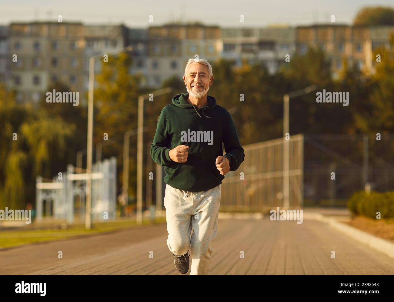 Happy joyful mature retired sportsman doing sports and running in ...