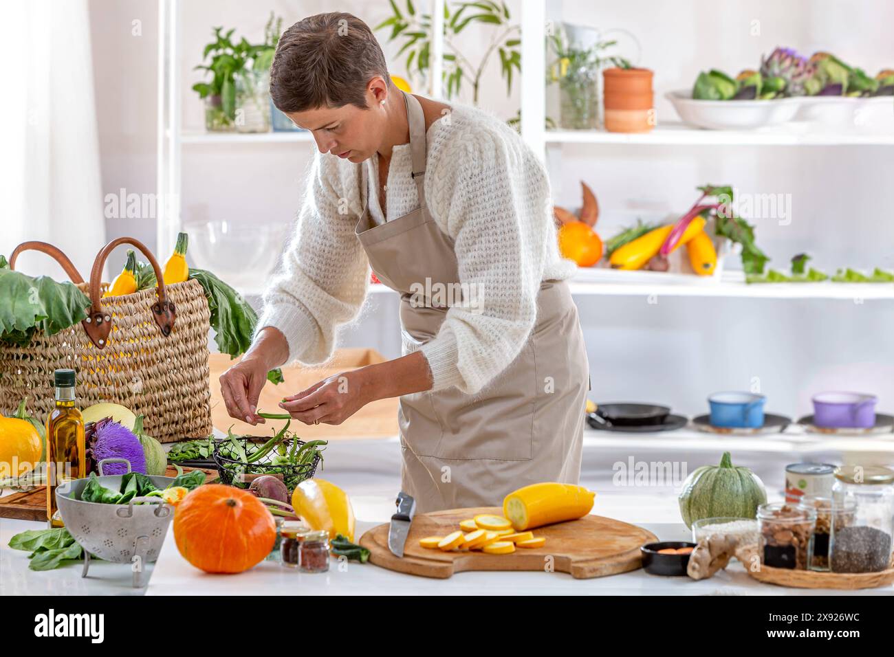 Young woman preparing green beans Vegan kitchen, the worktop filled ...