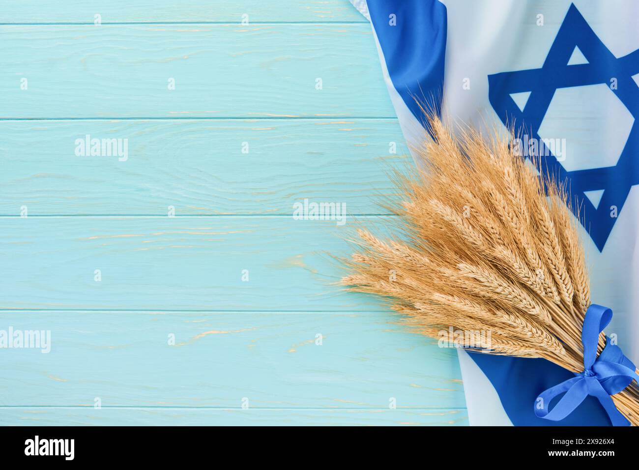Shavuot jewish background. Ripe bouquet of wheat with blue ribbon with ...