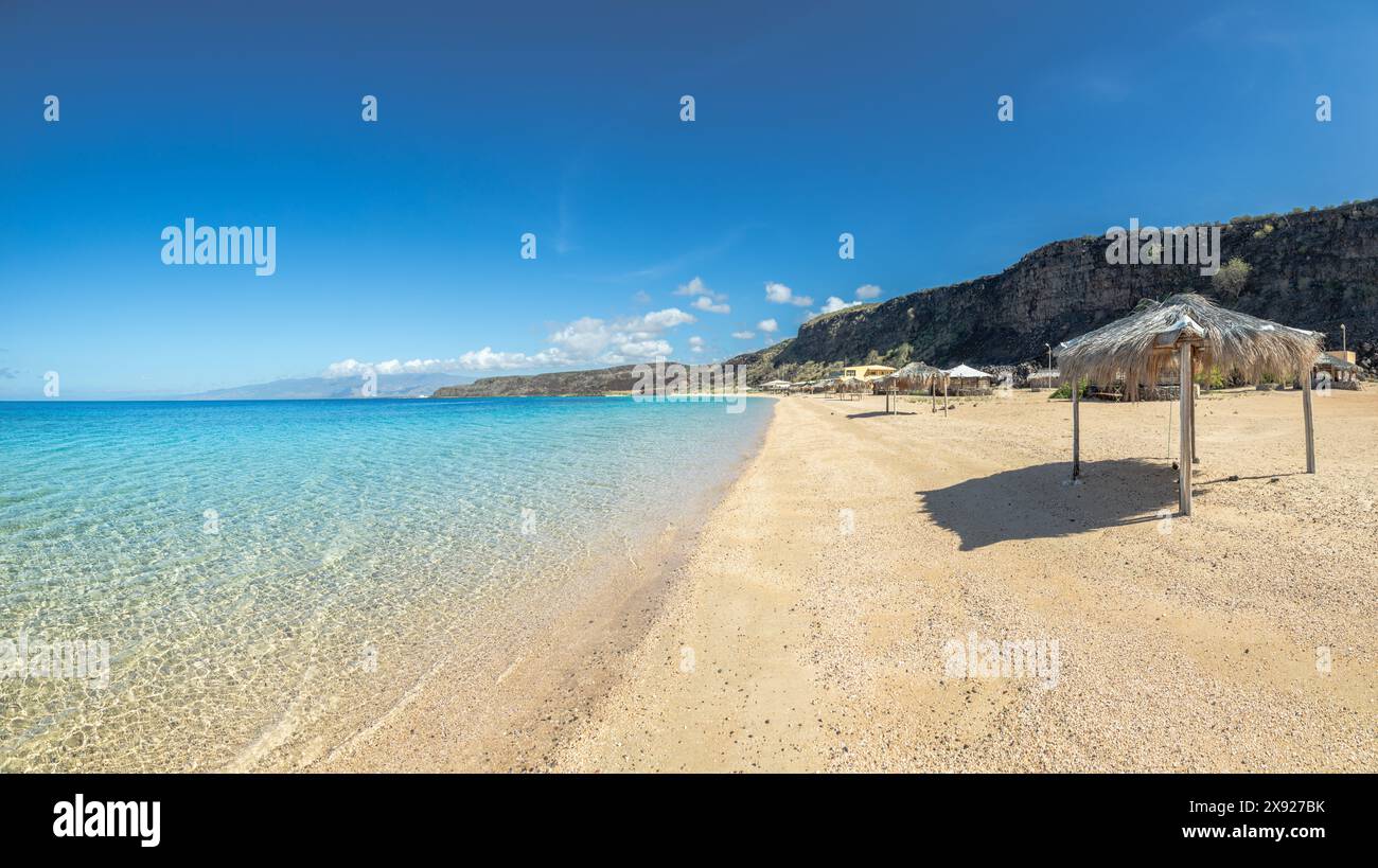 Sable Blanc sand beach with straw roofed huts and turquoise sea ...
