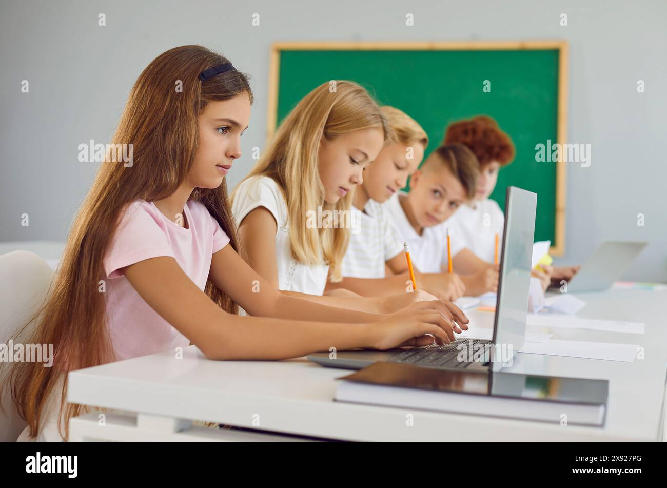 Group of junior high school students are studying using laptop in ...