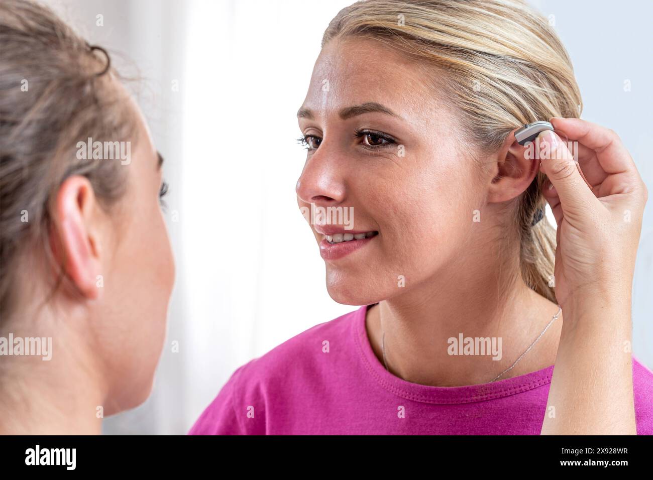 Close-up of fitting a hearing aid at the audiologist. Hearing problems ...