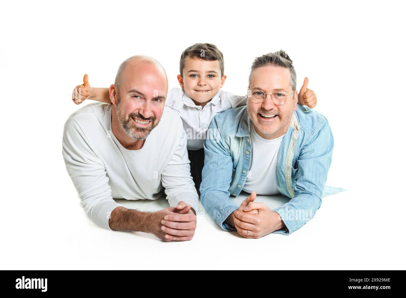 Two man couple with adopted child on white background Stock Photo - Alamy