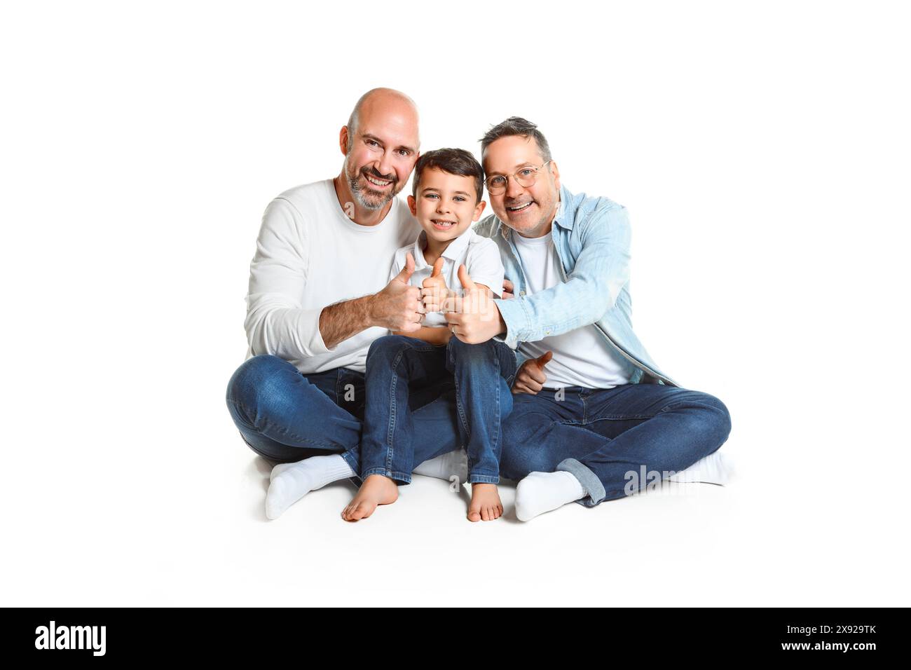 Two man couple with adopted child on white background Stock Photo - Alamy