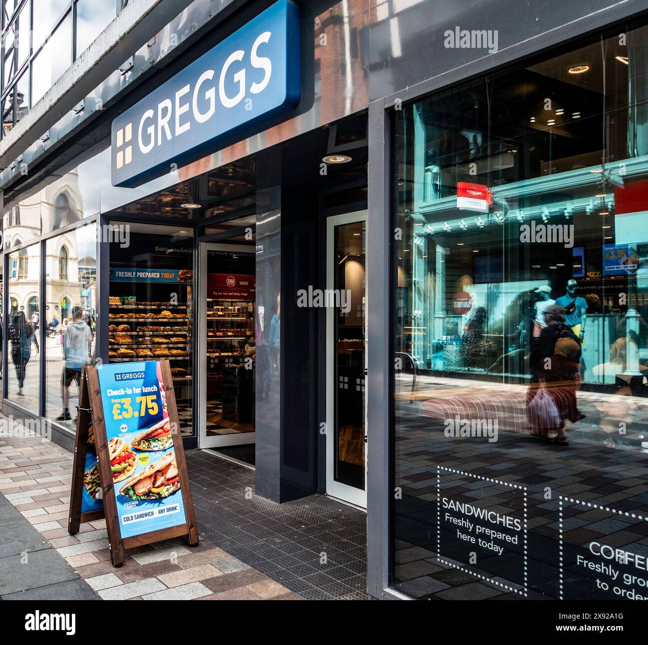 Pedestrians walk past a Greggs bakery storefront in Belfast, Northern ...