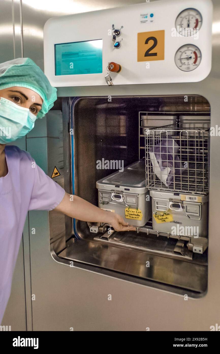 Operator with ancillary cart in front of the autoclave sterilizer ...