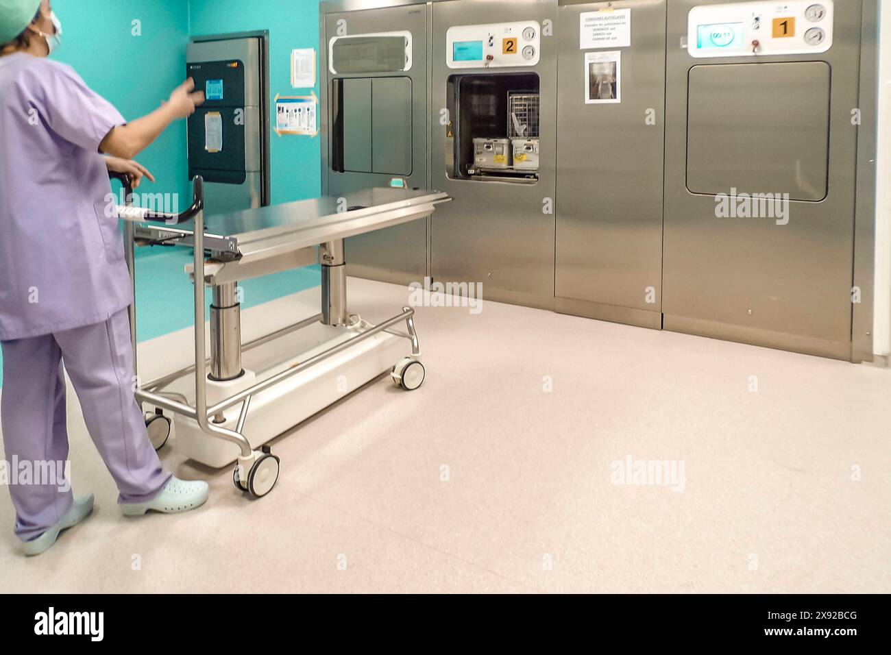 2 operators with trolley in front of the autoclave sterilizer ...