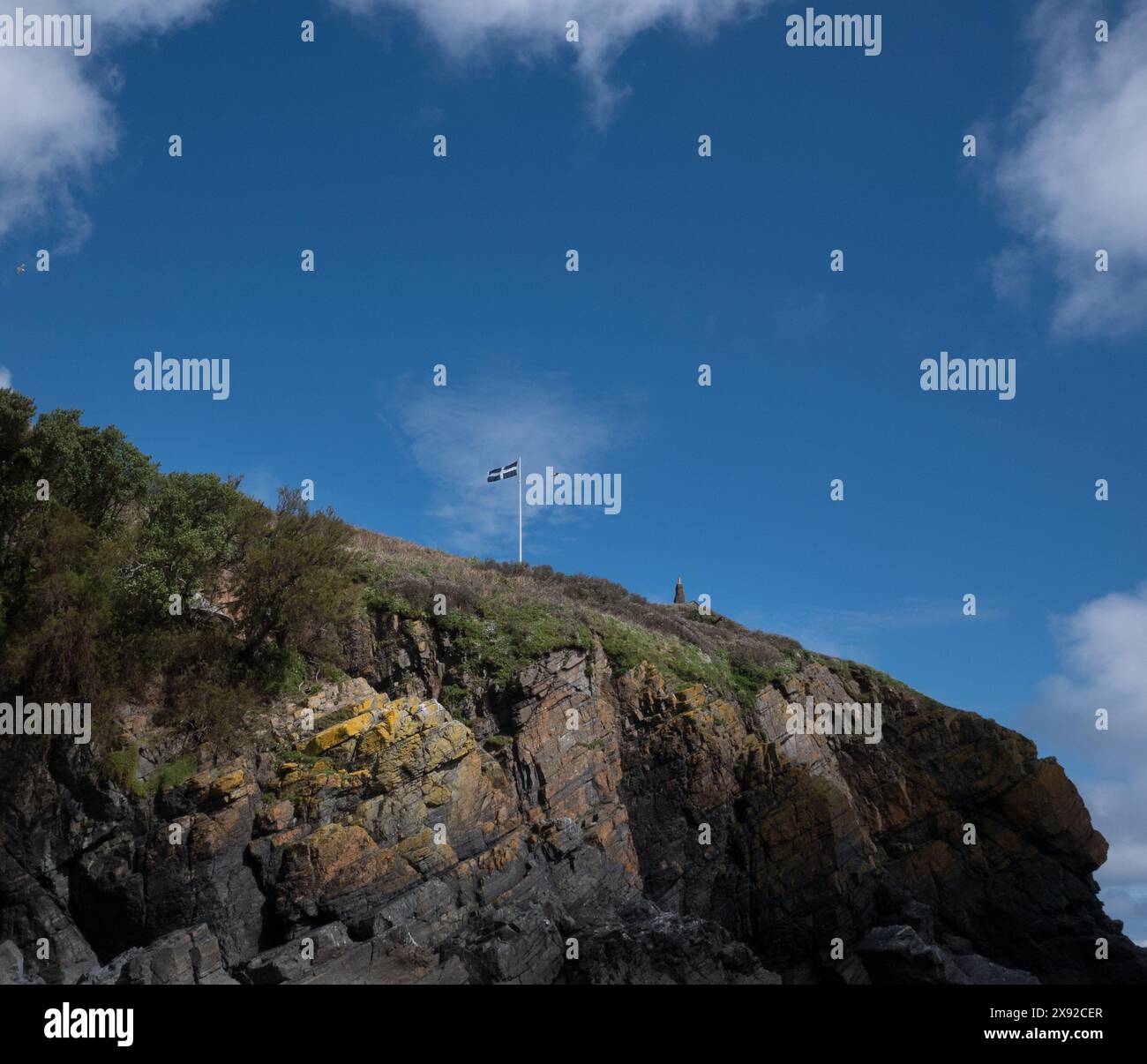 St Piran flag flying above the cliffs at Cadgwith fishing village ...