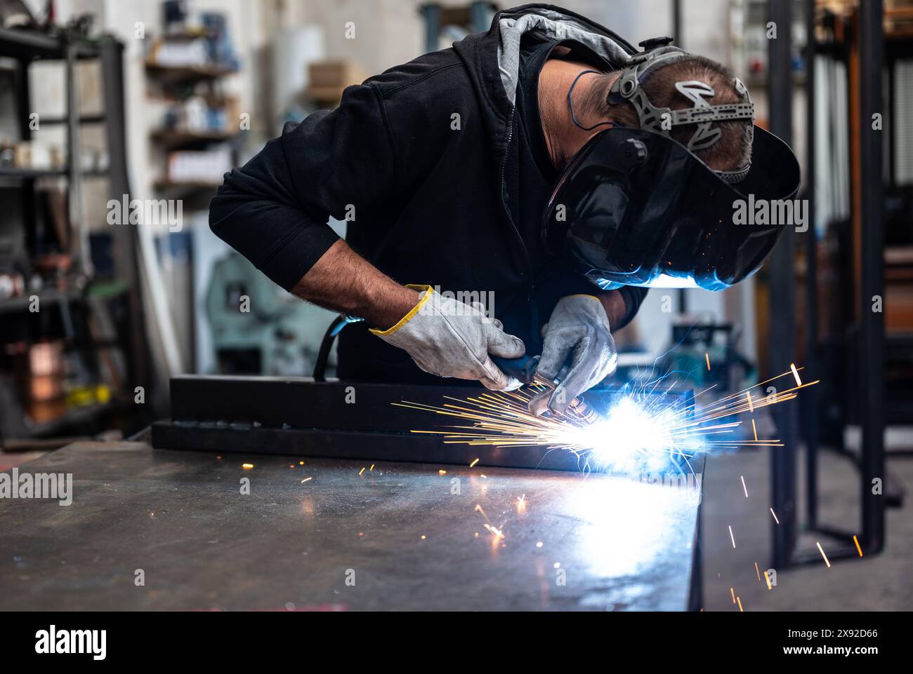 Performing a weld: the man in the welding mask is positioned with the ...
