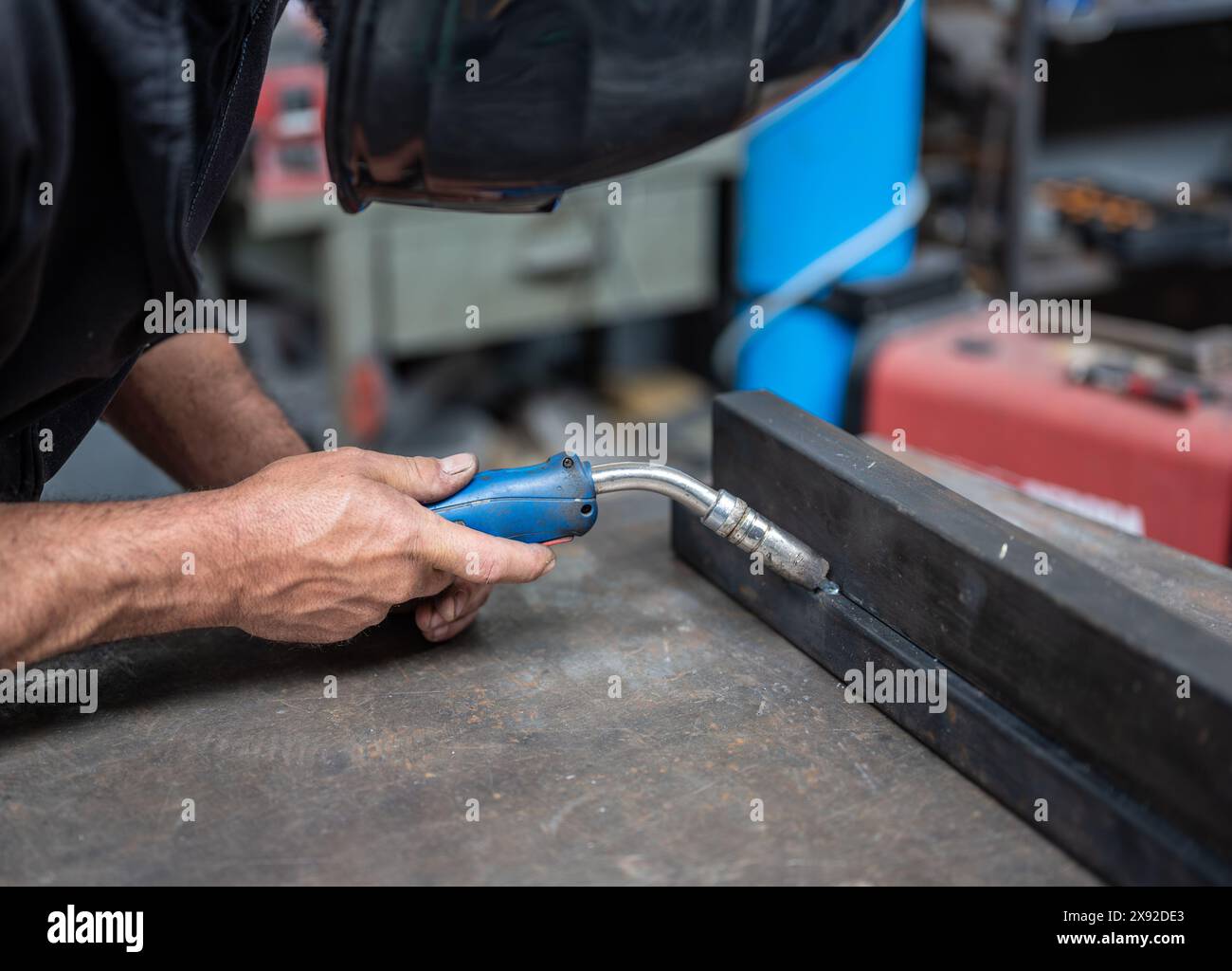 Carrying out a weld: the man with the welding mask positions himself ...