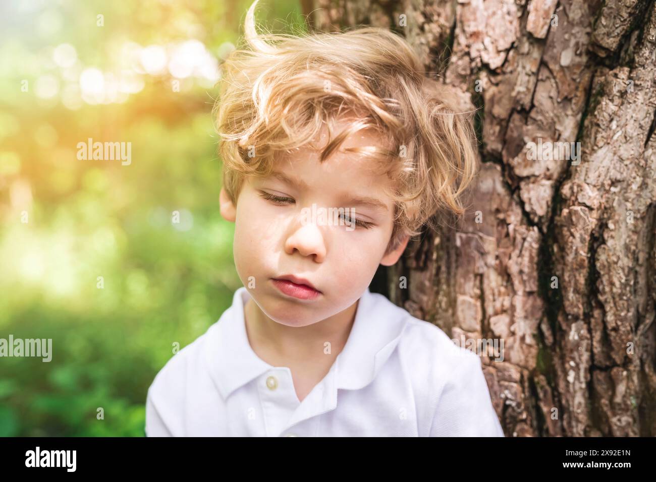 boy along in summer park. Child in green woods Stock Photo - Alamy