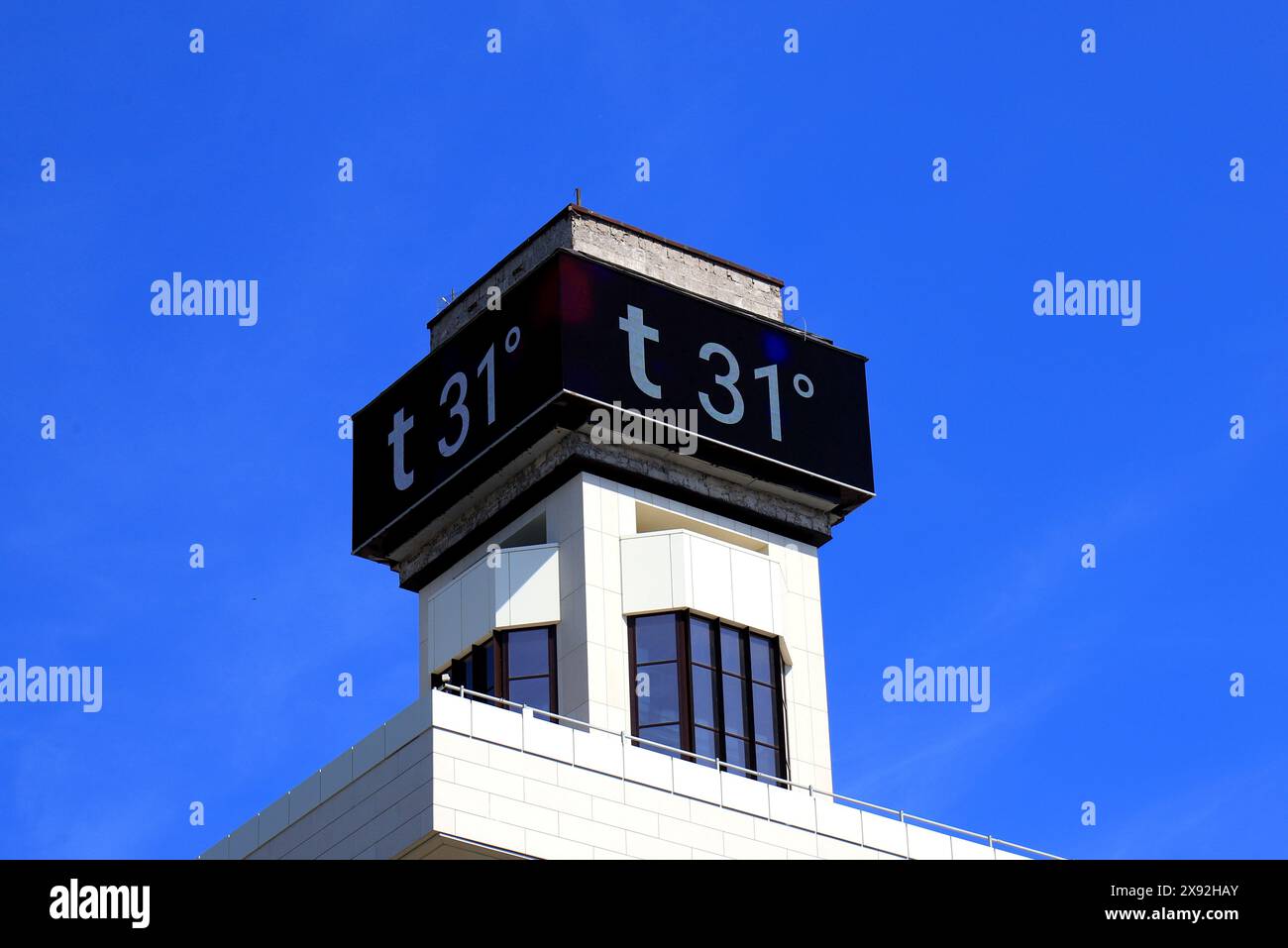 A large electronic thermometer outside shows high summer temperatures ...