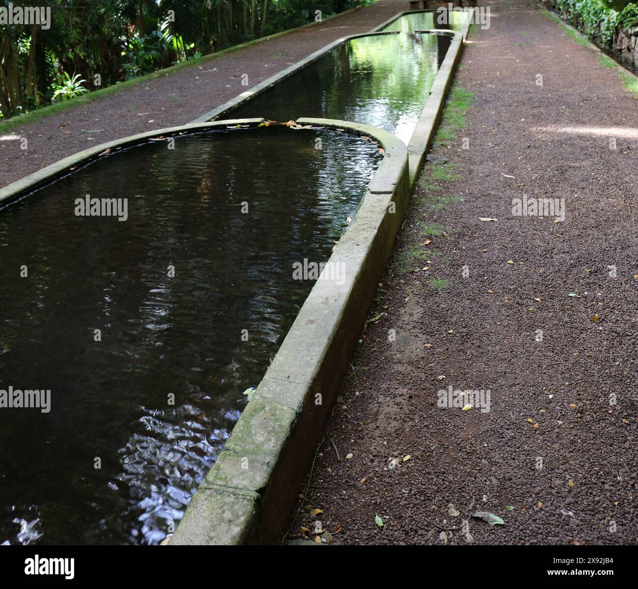 A three tiered reflection pond, with gravel paths on both sides, at the ...