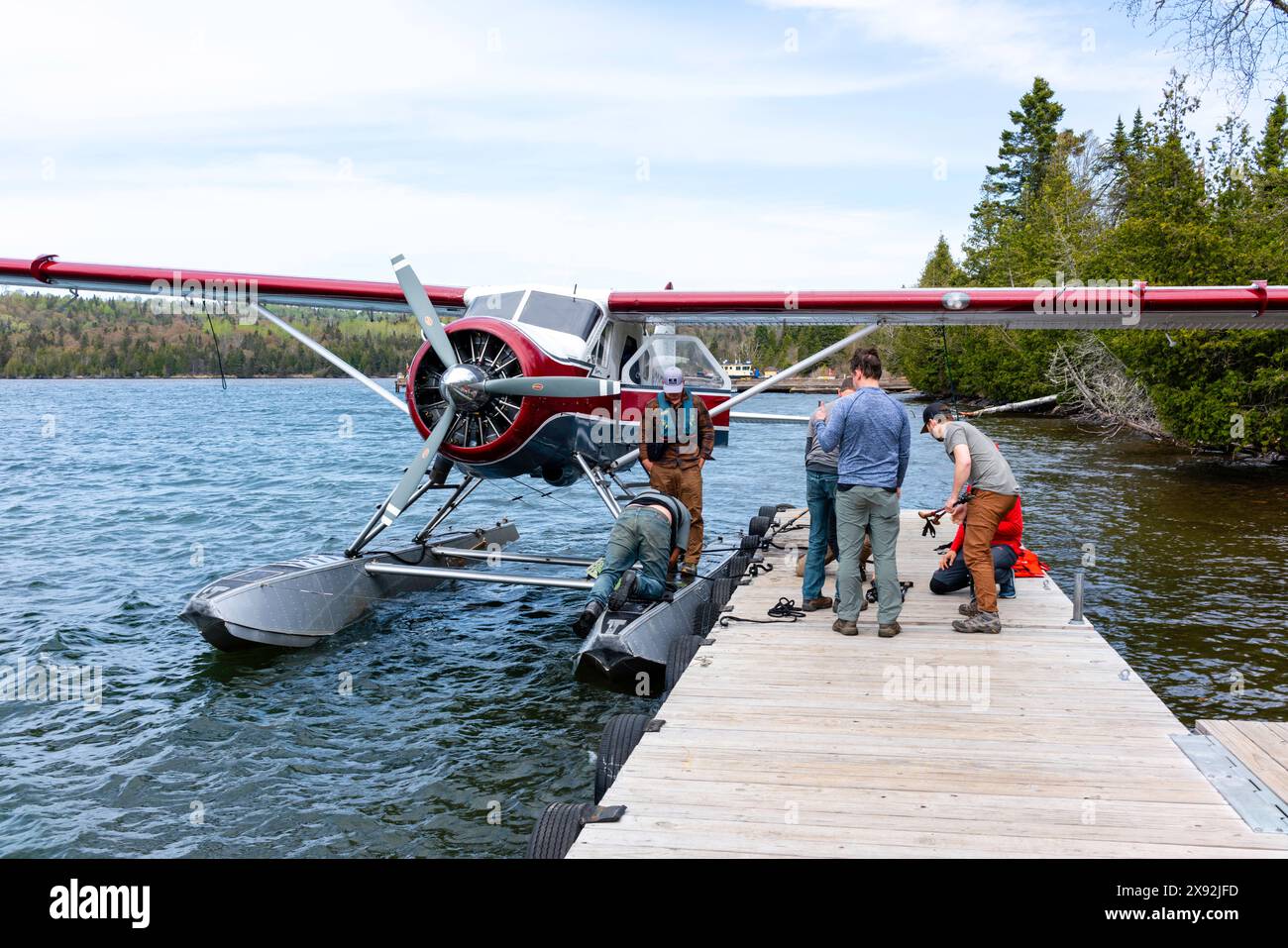 Pilots and guests unload gear from a seaplanes at the WIndigo dock ...