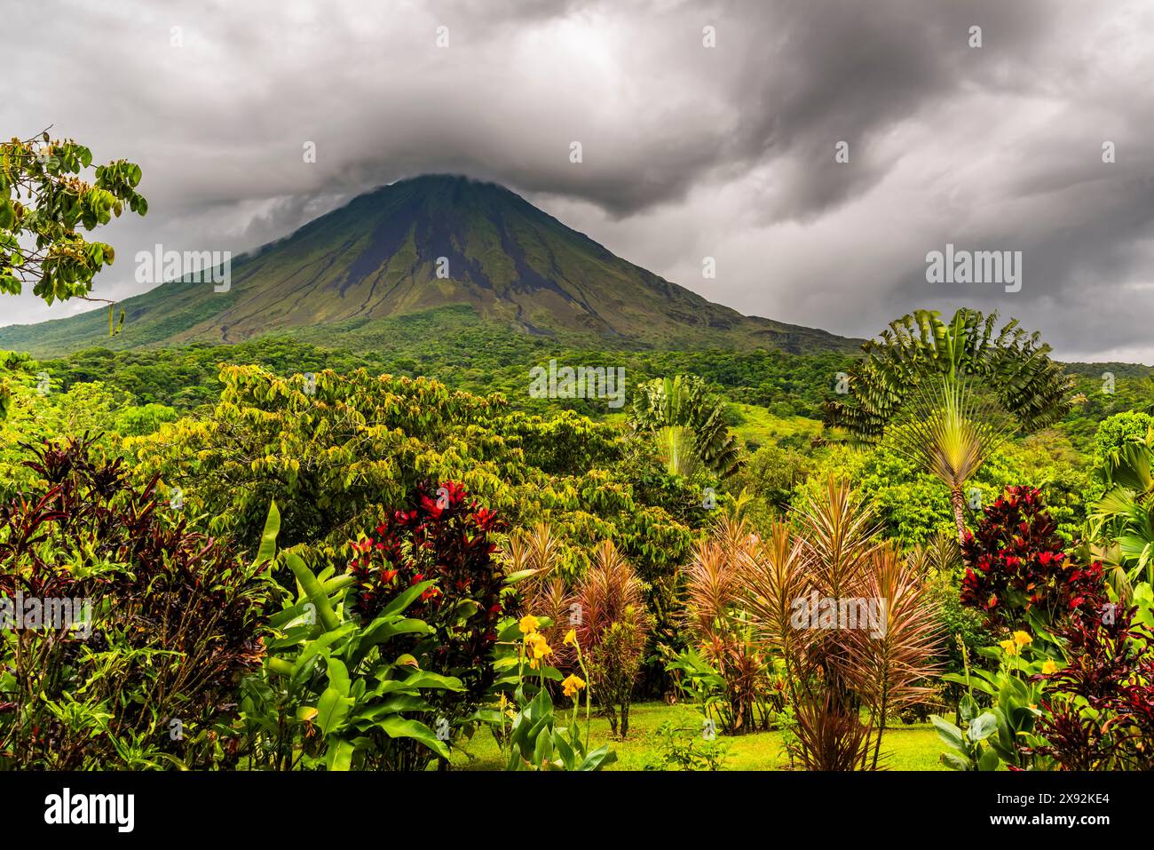 View over the Arenal Volcano at dusk on a stormy day, La Fortuna ...