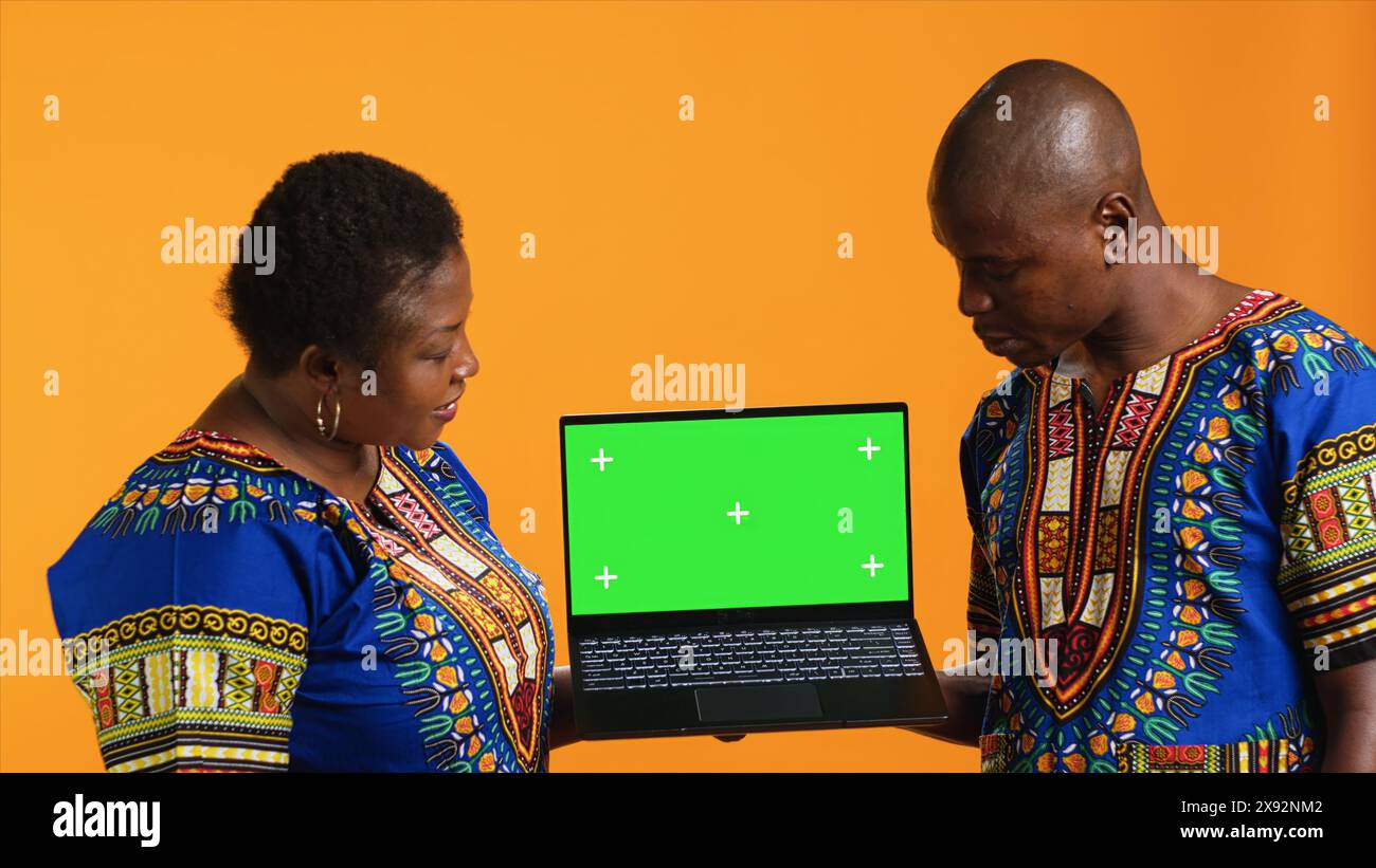 Ethnic people pointing to laptop with greenscreen layout, posing on ...