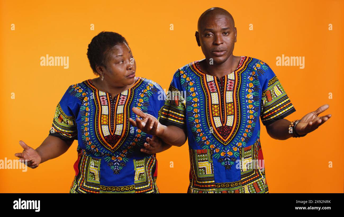 Clueless man and woman doing i dont know sign in studio, expressing ...