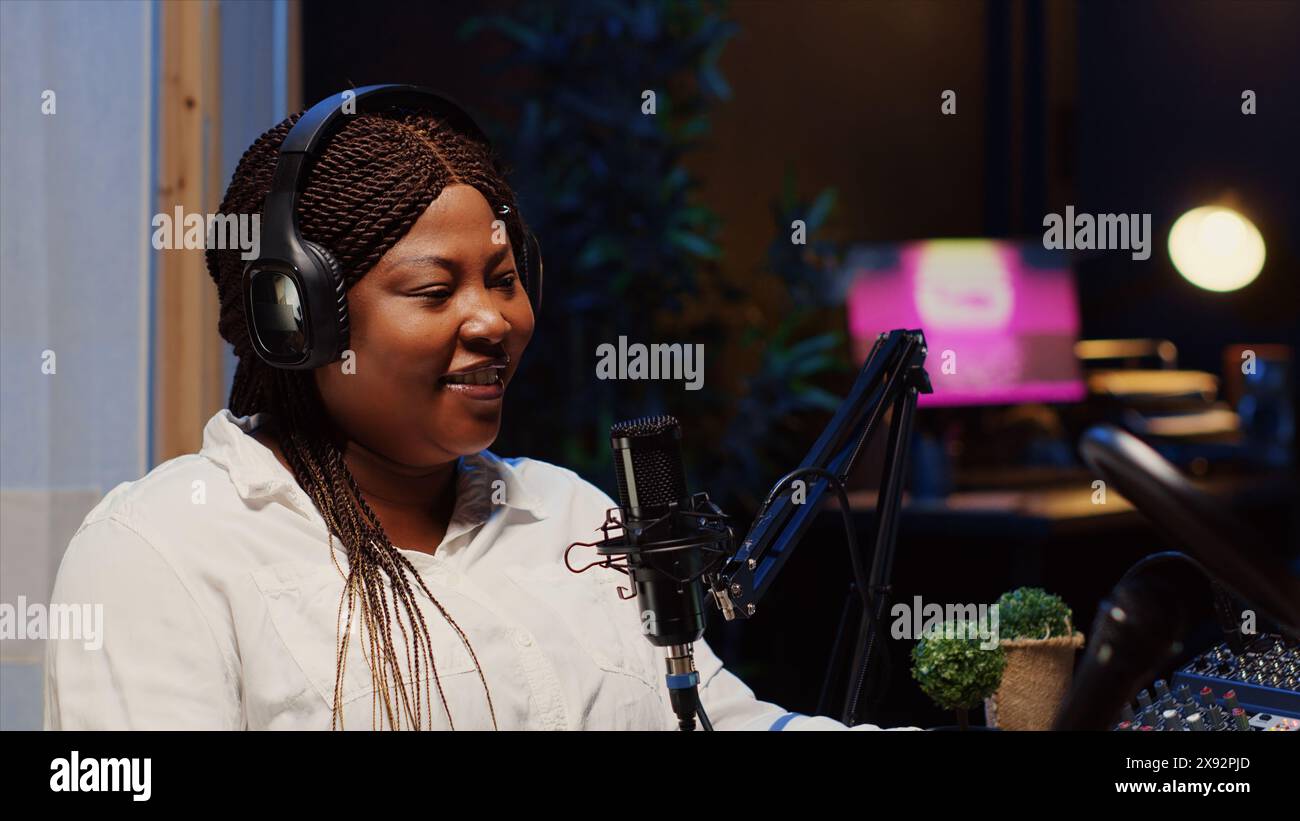 African american woman doing podcast in apartment studio, wearing ...