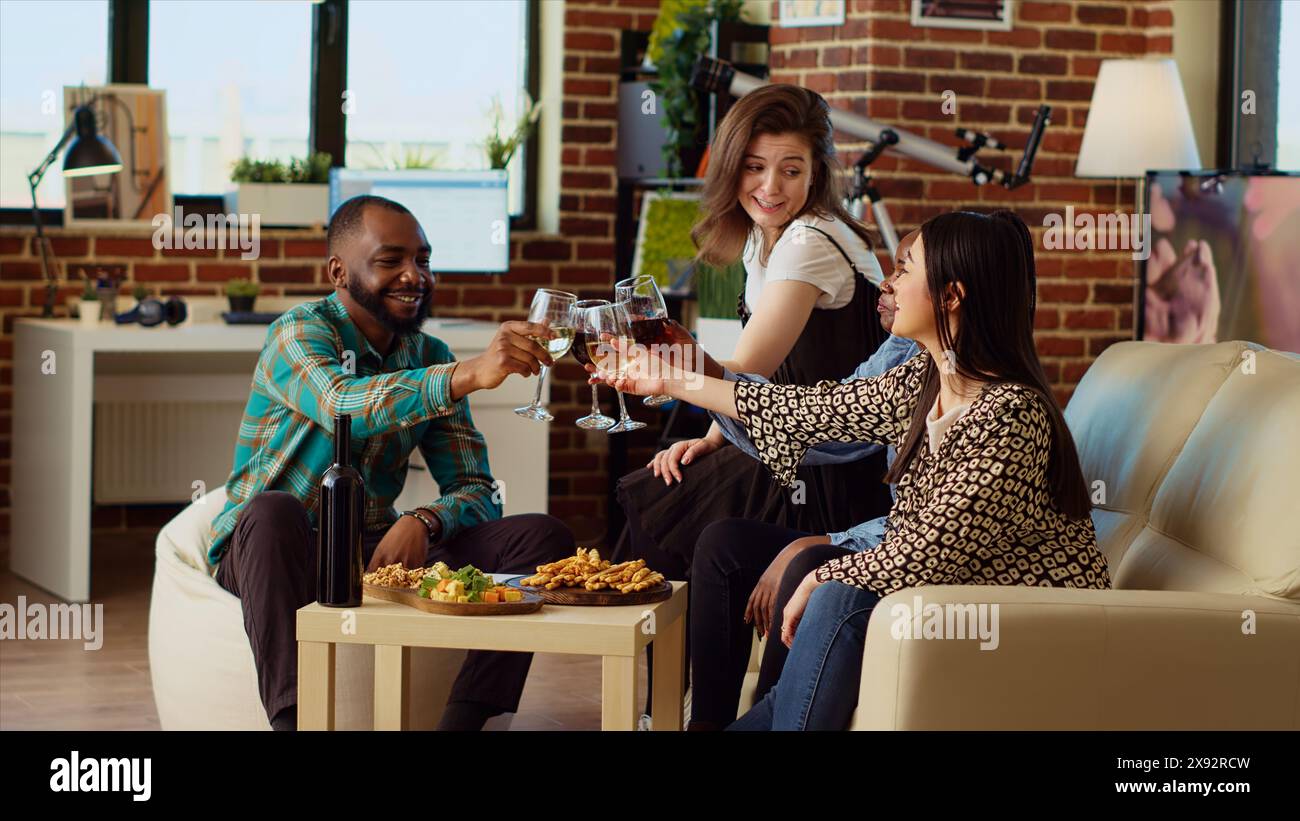 Diverse group of people celebrating their friendship together, clinking ...