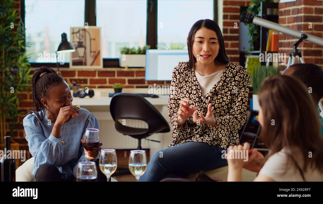 Asian woman entertaining friends at apartment party, sharing with them ...