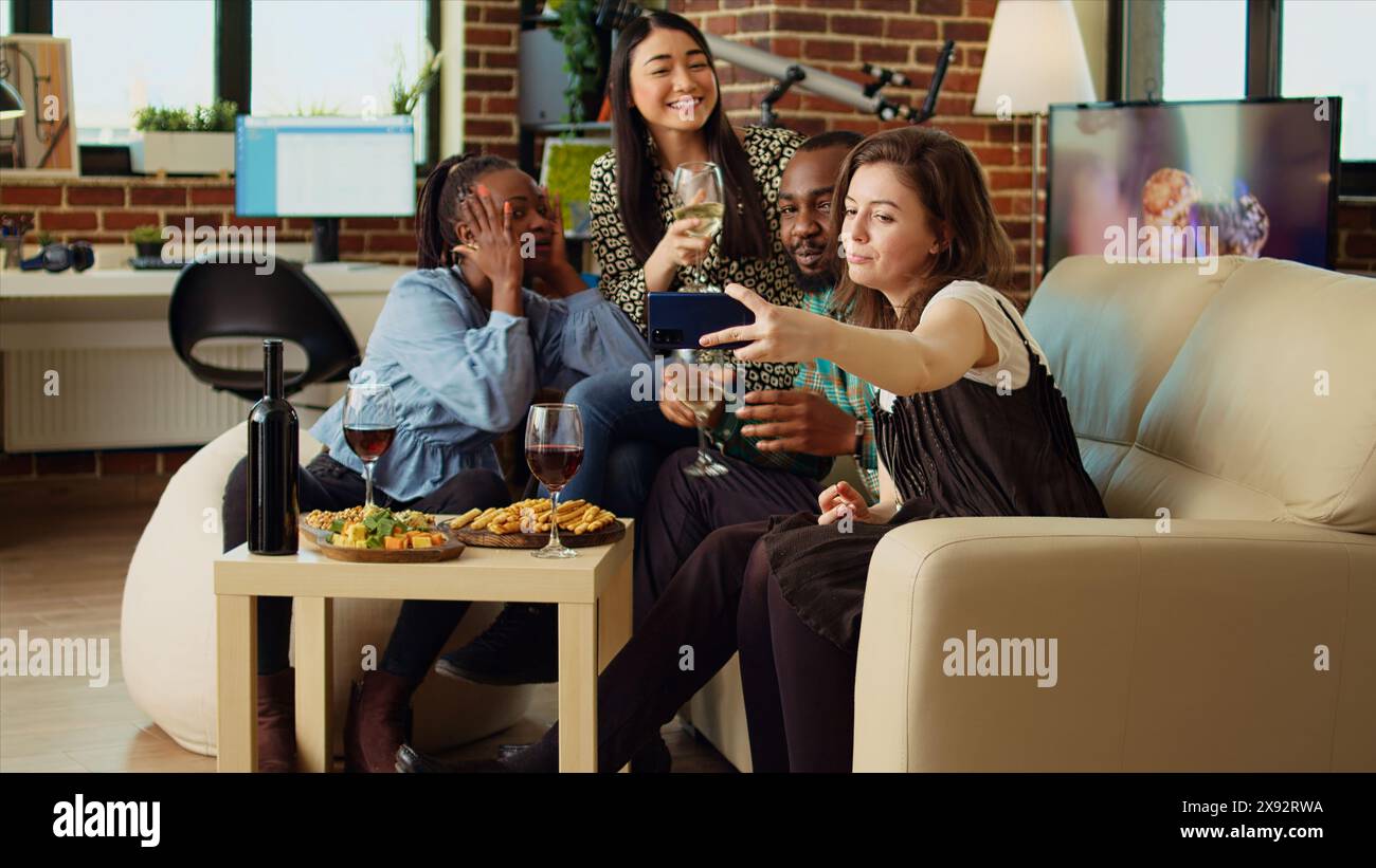 Multiethnic friends taking group pictures with cellphone at apartment ...