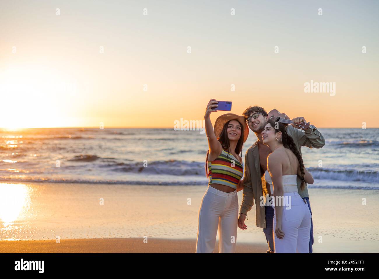copyspace group of Latin friends gather to take a selfie on the beach shore during a beautiful ...