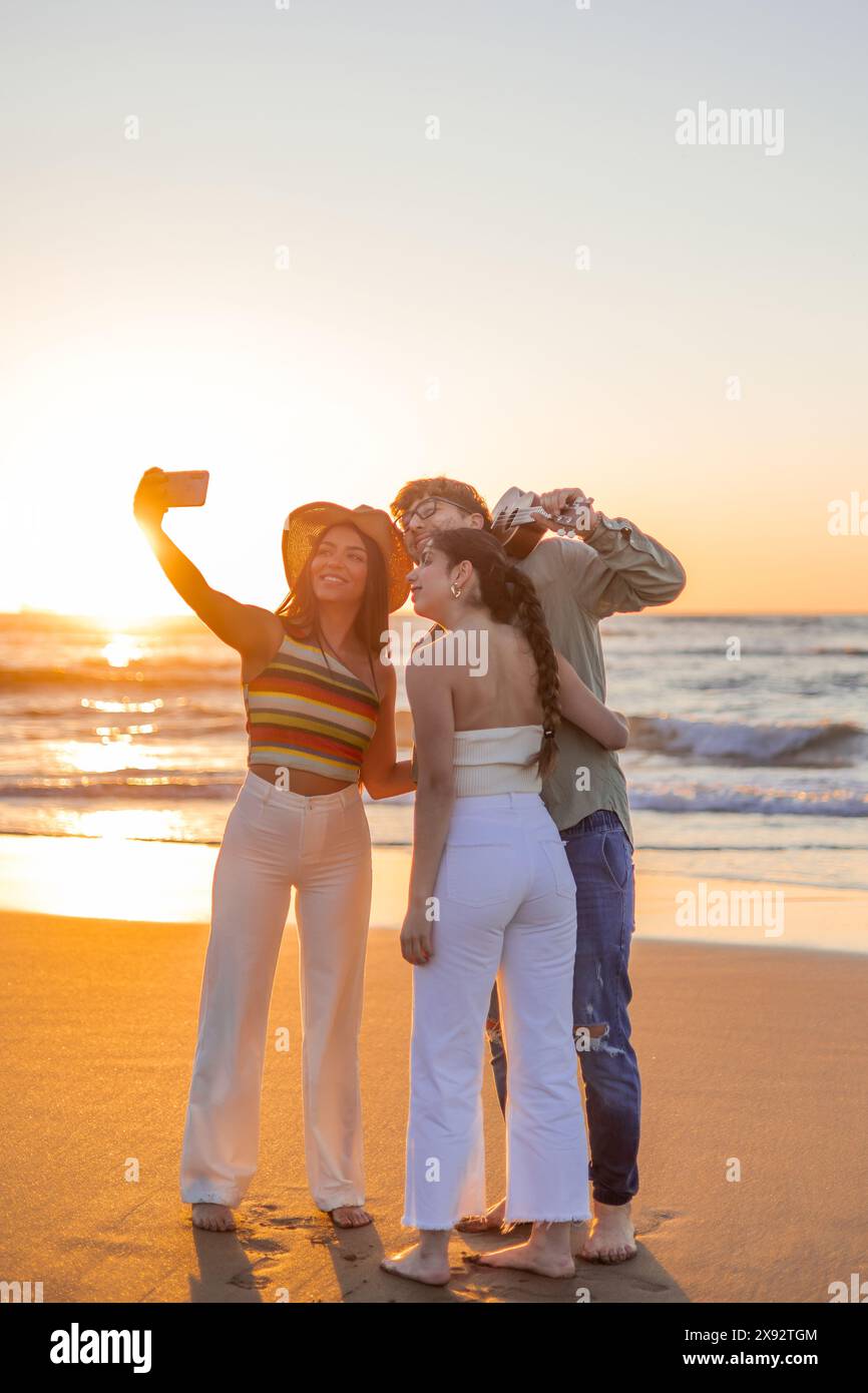 vertical diverse group of friends gathers on the beach at sunset ...