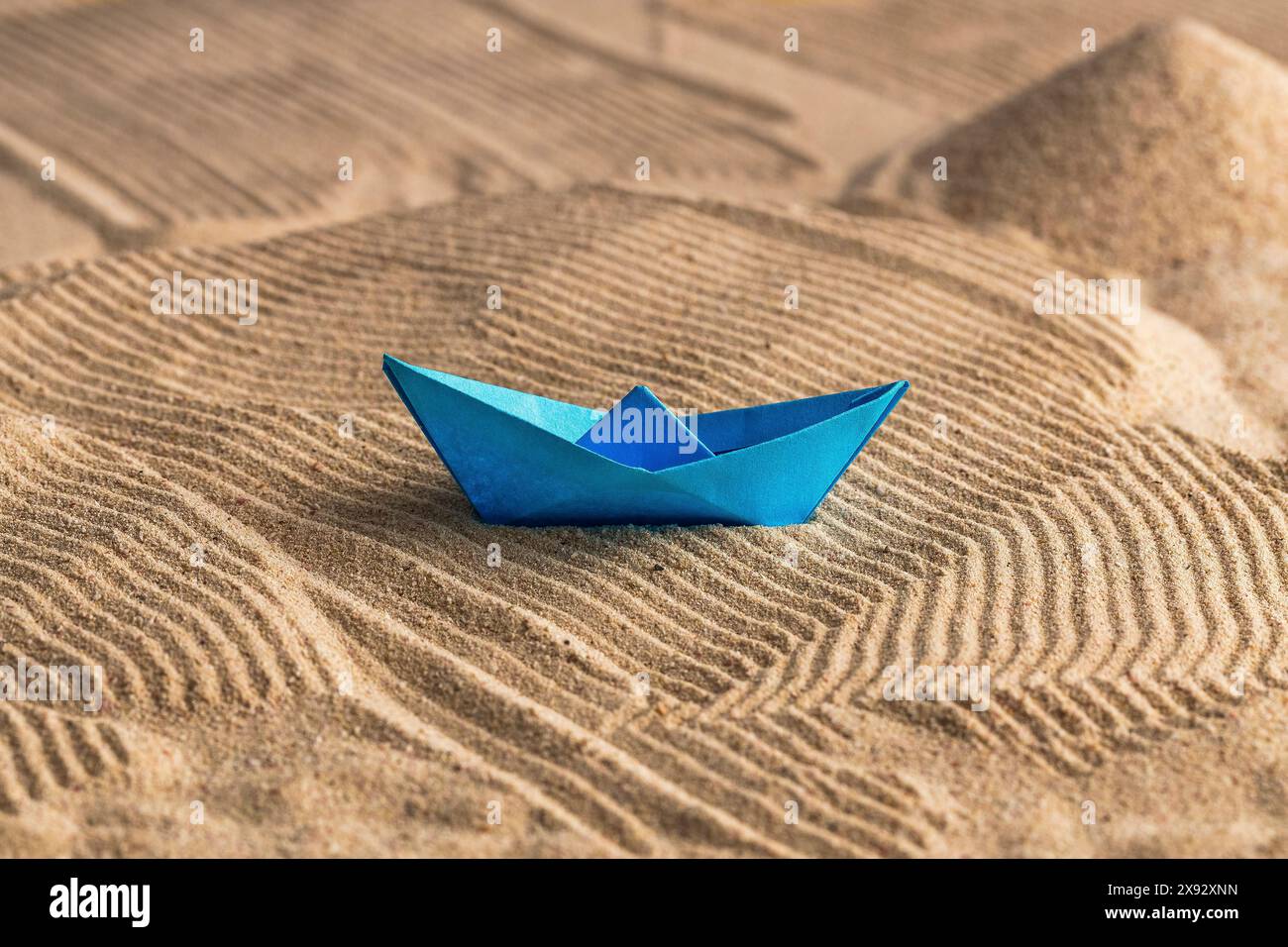 Sand dune with blue paper boat - Art for decoration Stock Photo - Alamy
