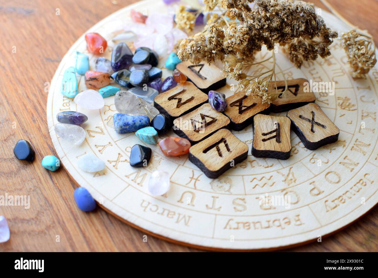 Scandinavian runes made of amethyst and rose quartz crystals on a board ...