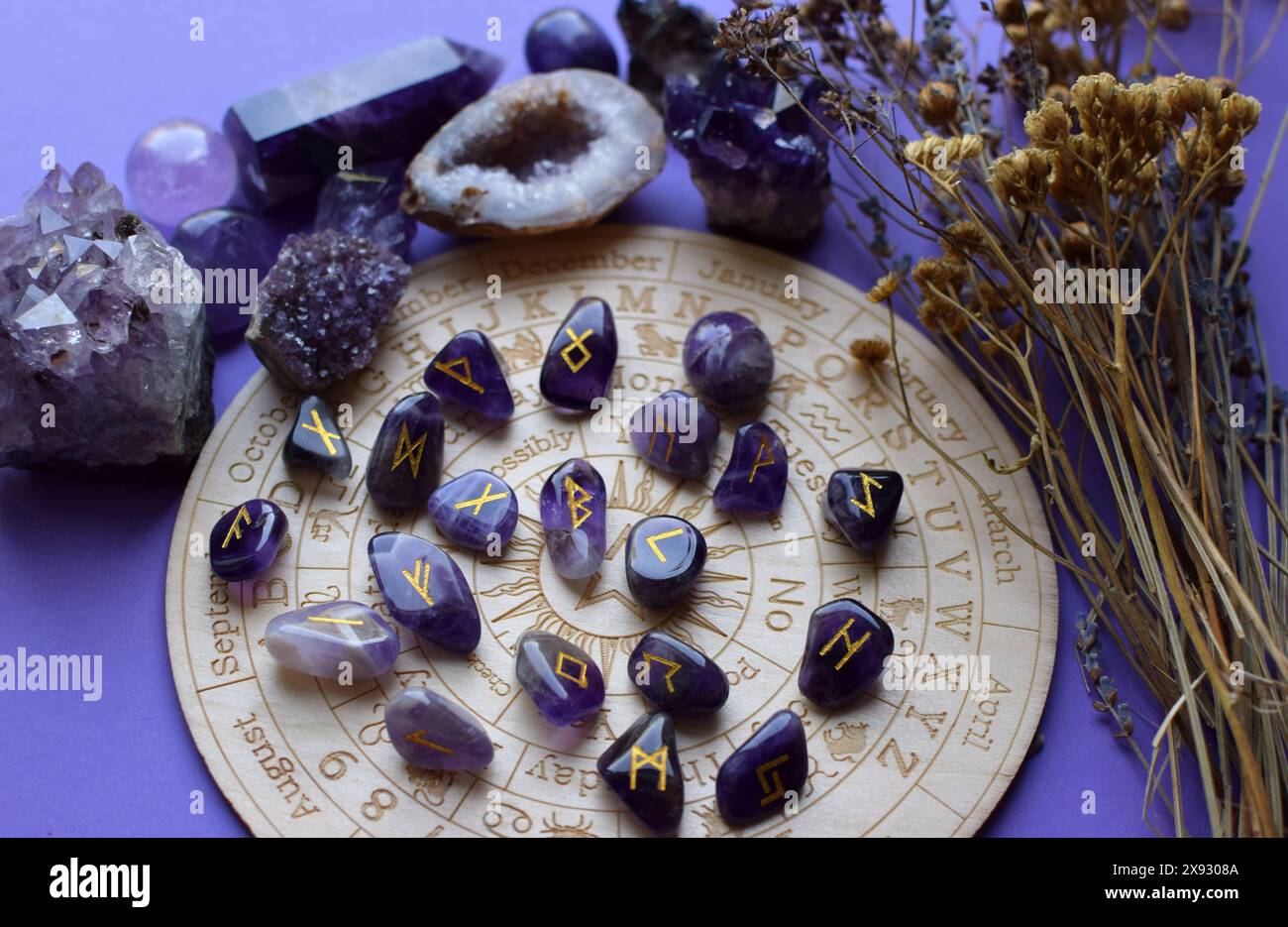 Amethyst crystals, Scandinavian runes and dry herbs on a purple ...