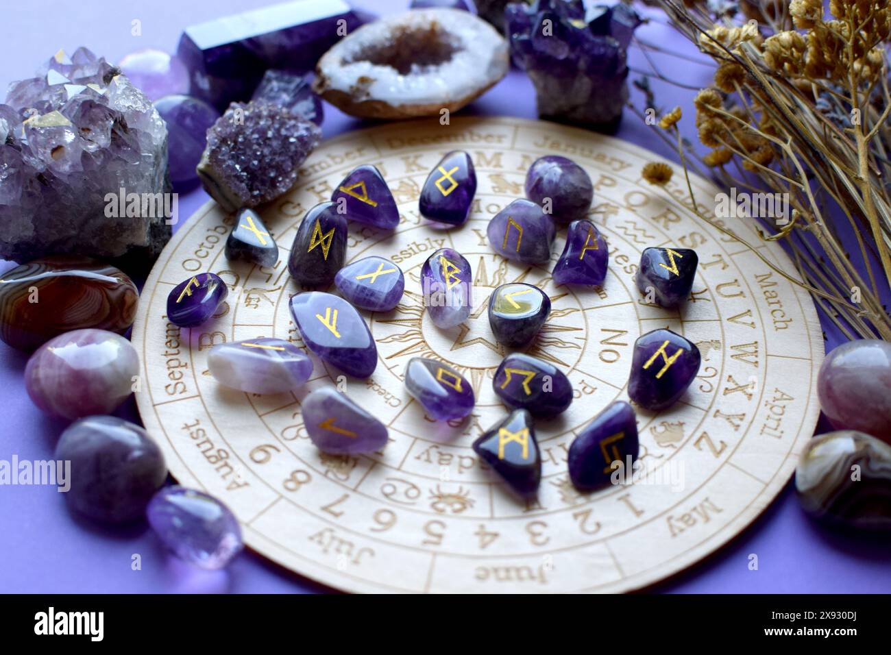 Amethyst crystals, Scandinavian runes and dry herbs on a purple ...