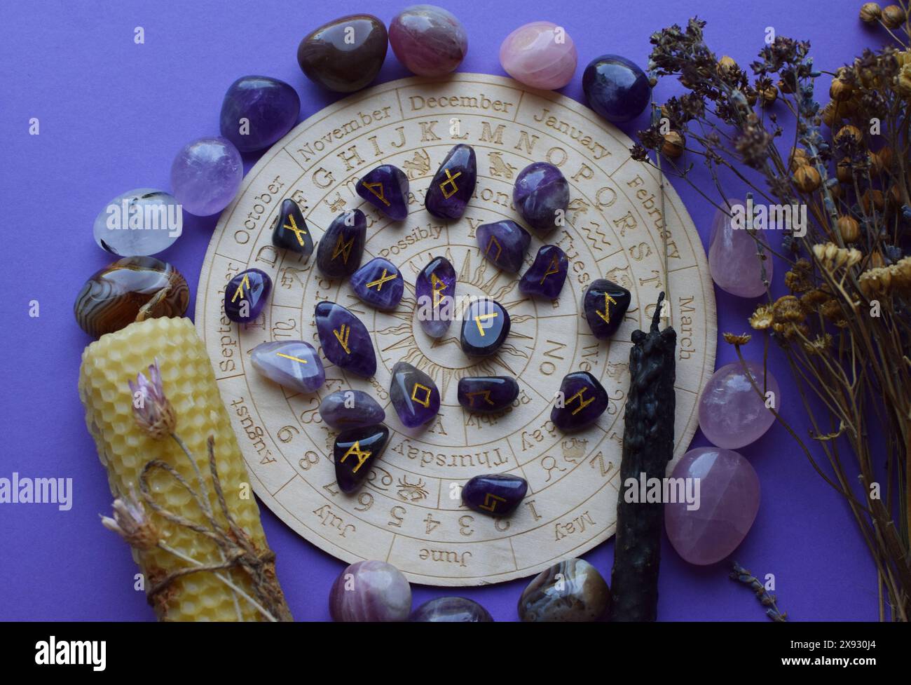 Scandinavian runes from amethyst and dry herbs on a purple background ...