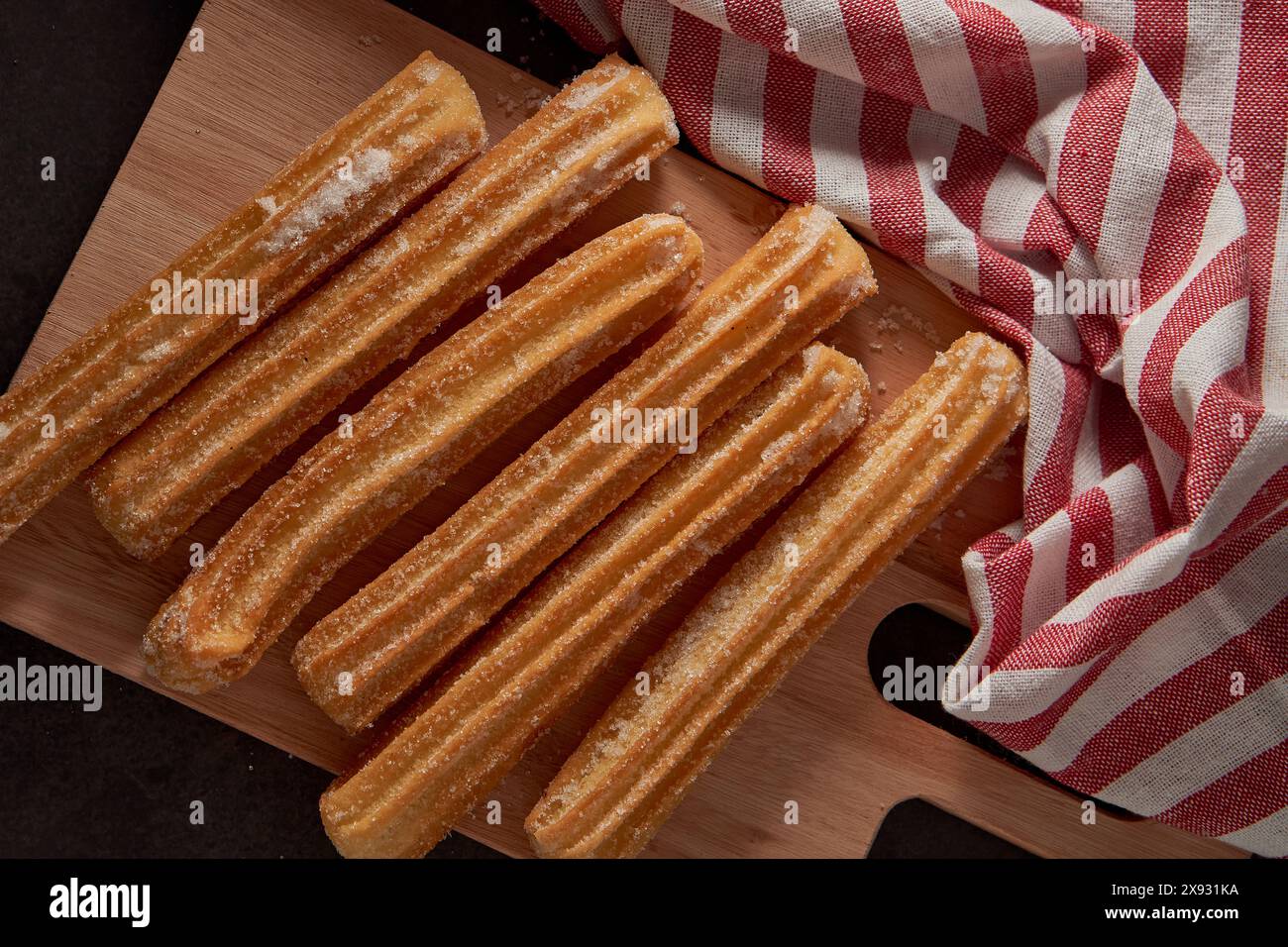homemade Churros argentine with sugar on a wooden board and a cloth ...