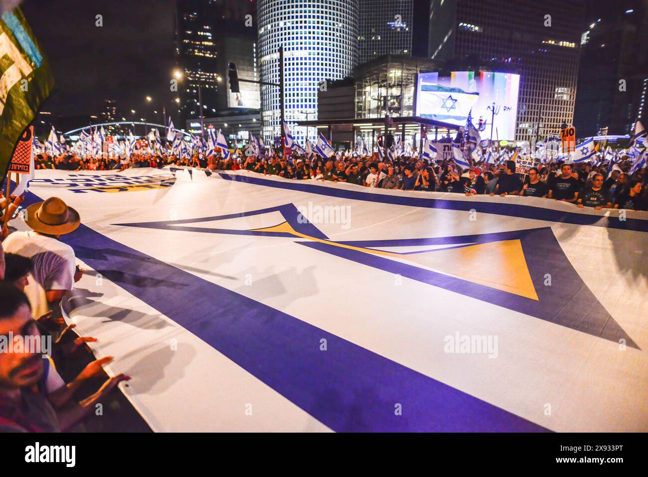 Tel Aviv, Israel. 25th May, 2024. Protestors hold a giant Israel flag ...