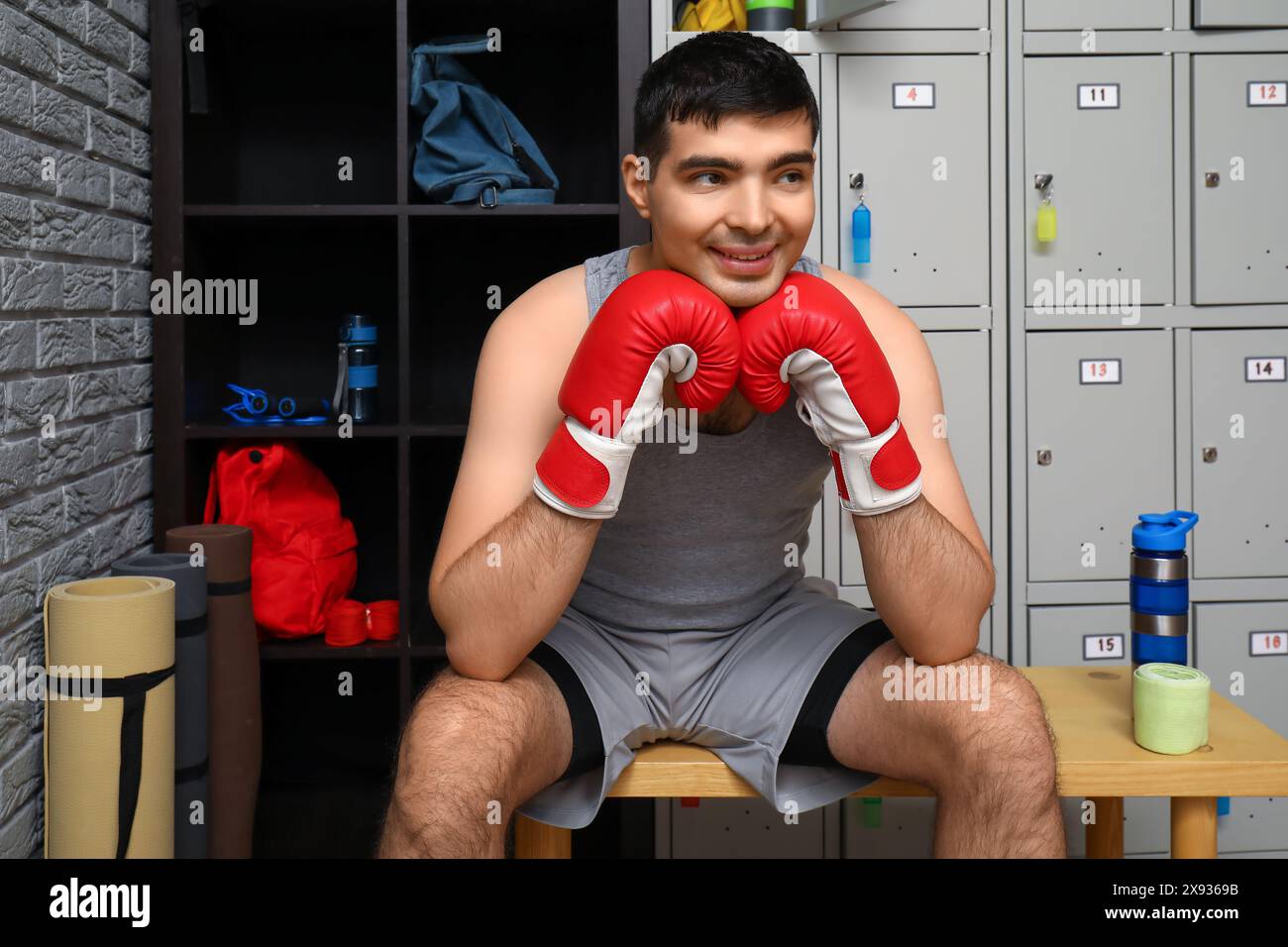 Sporty young man with boxing gloves near locker in changing room Stock ...