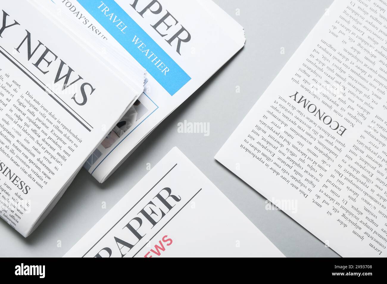 Different newspapers on grey background Stock Photo - Alamy