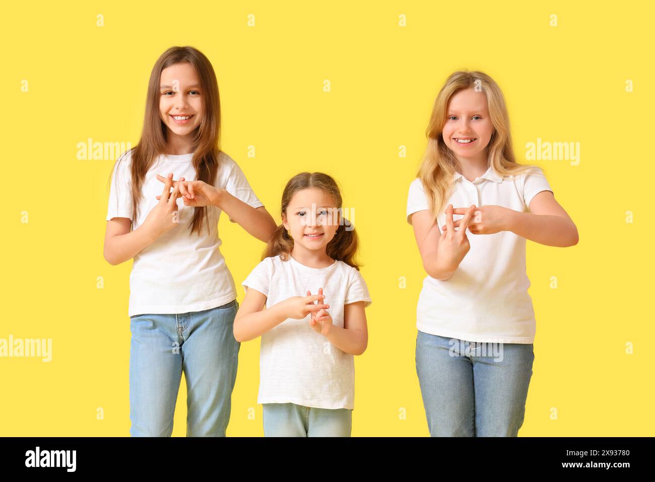 Cute little girls making hashtag gesture on yellow background Stock ...