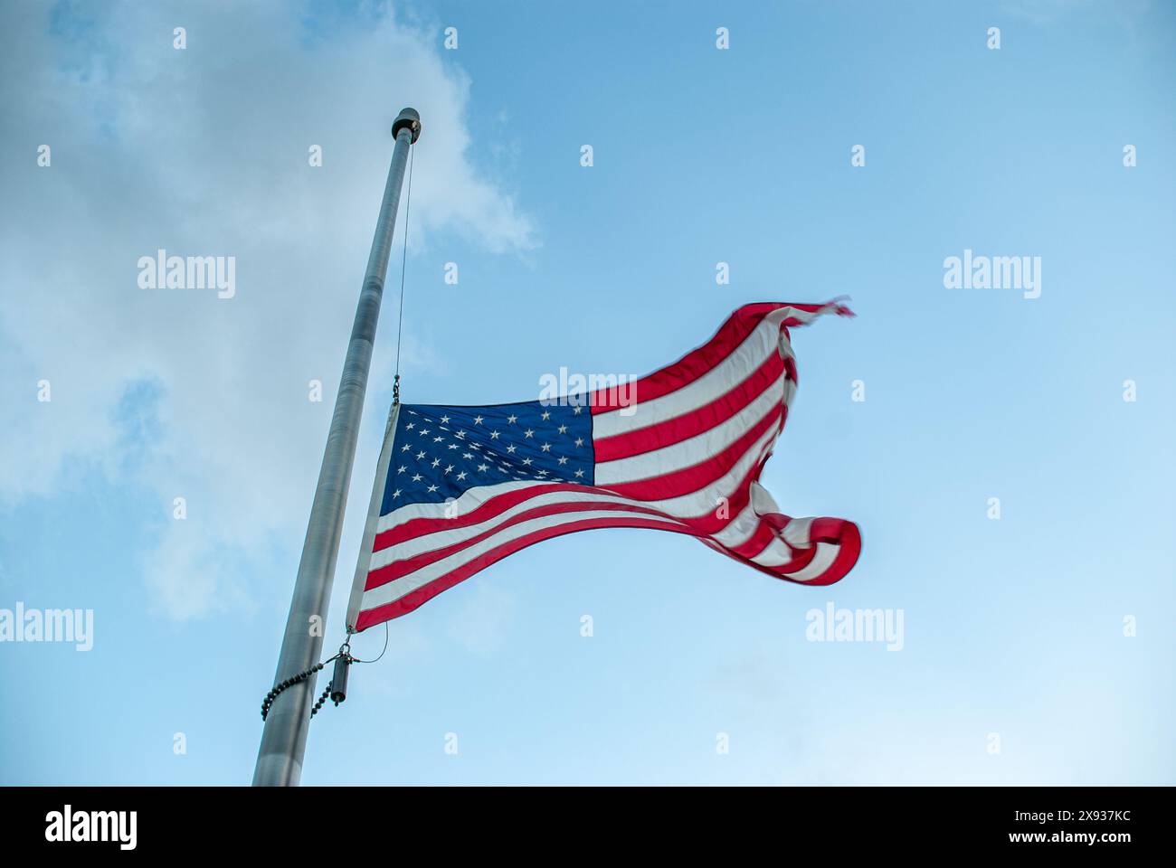 American flag at half mast for memorial day weekend on a sunny day ...