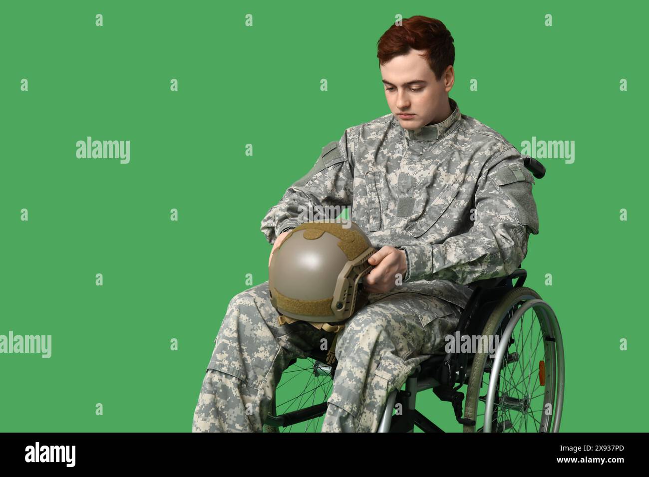 Male soldier in wheelchair on green background Stock Photo - Alamy