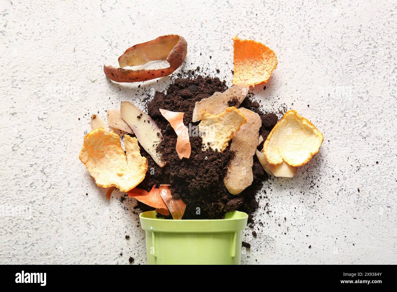 Bin with organic waste and soil on white grunge background. Compost ...