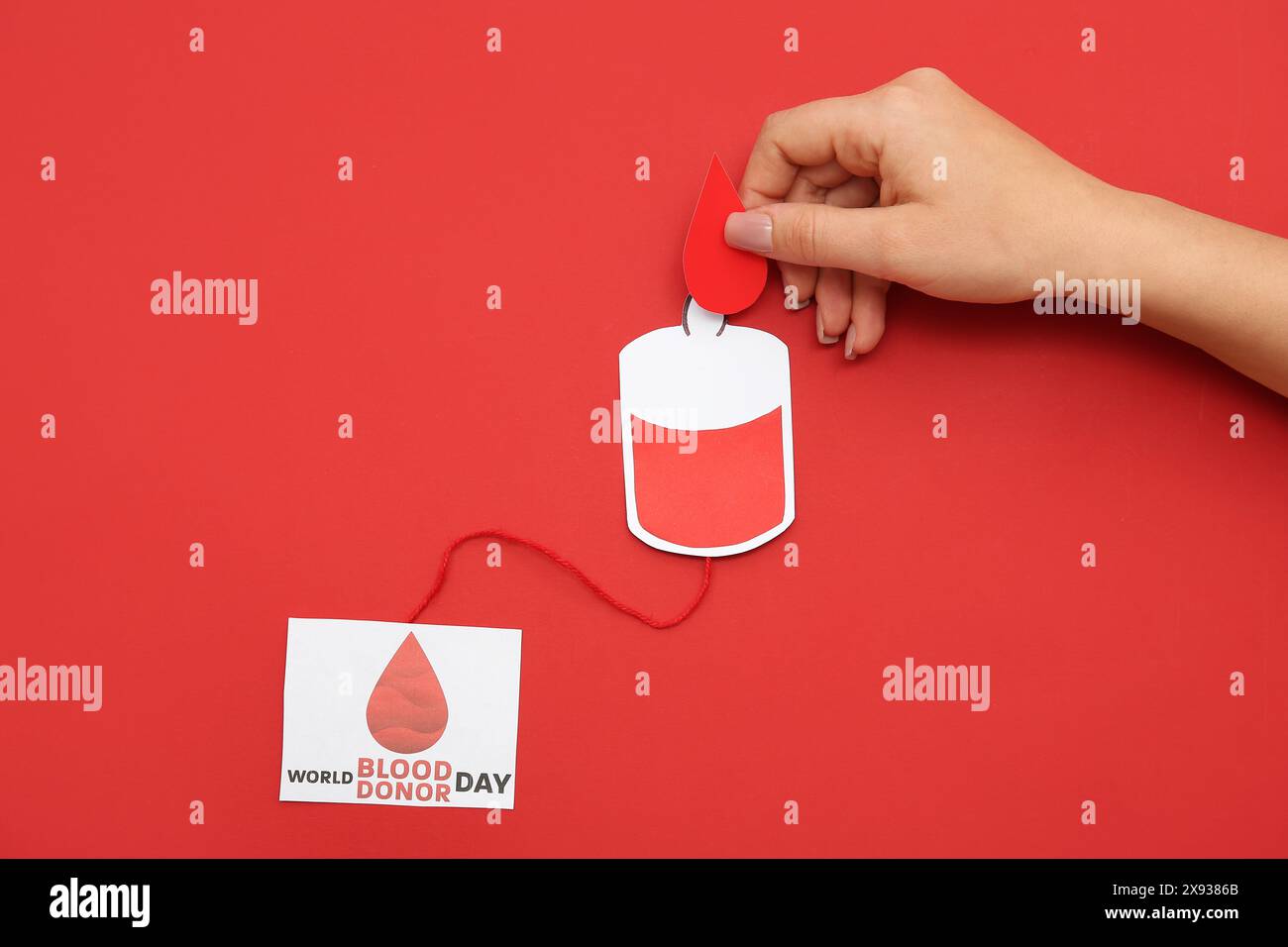 Female hand holding paper drop and paper blood pack for transfusion ...