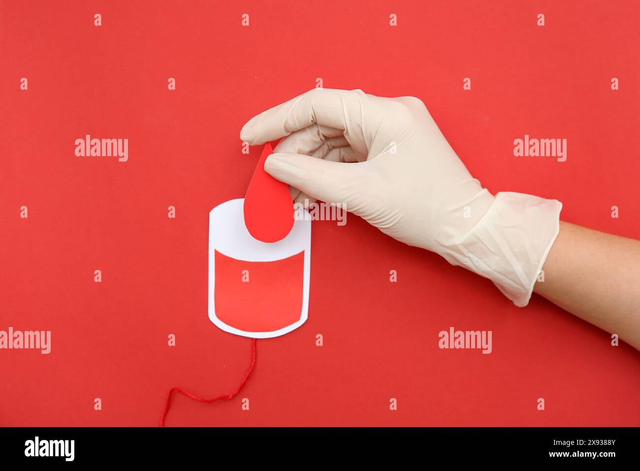 Female hand in rubber glove holding paper drop and paper blood pack for ...