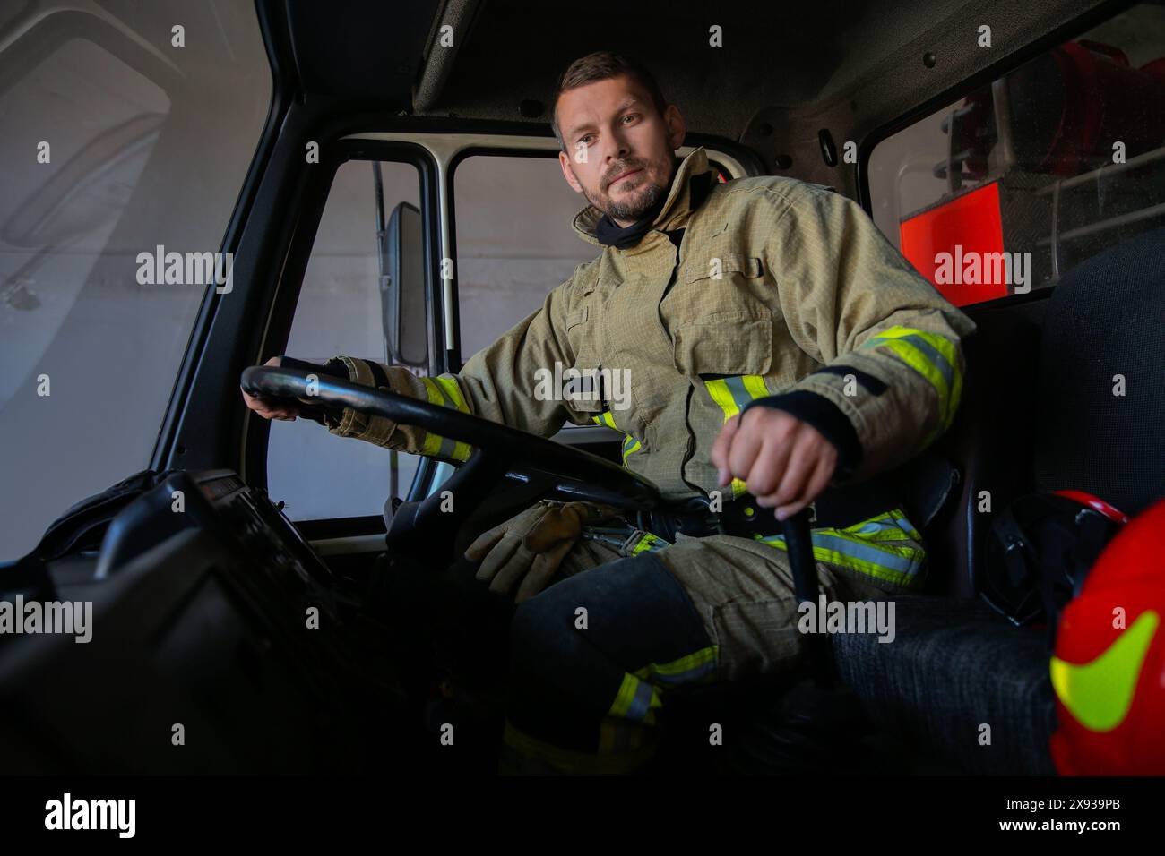 Firefighter in uniform driving modern fire truck Stock Photo - Alamy
