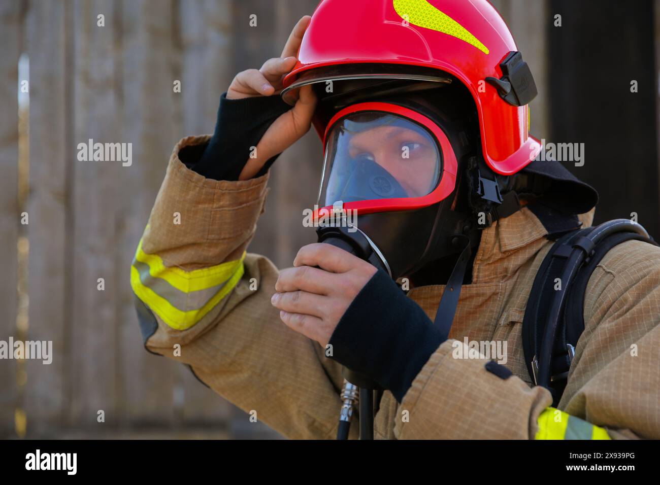 Firefighter in uniform wearing helmet and mask outdoors Stock Photo - Alamy