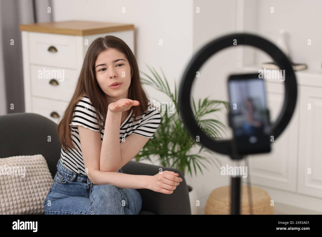 Teenage blogger sending air kiss to her subscribers while streaming at home Stock Photo - Alamy