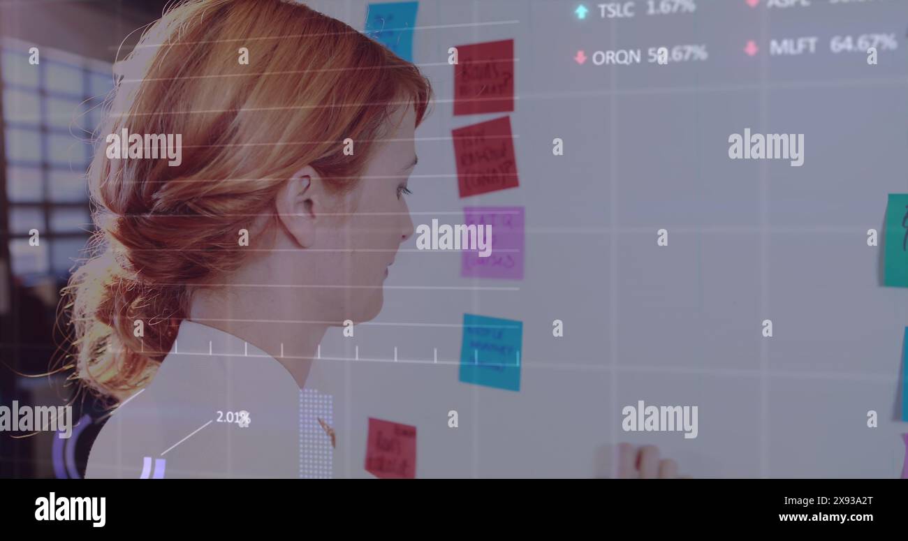 Caucasian woman in her early thirties looking at colorful sticky notes ...