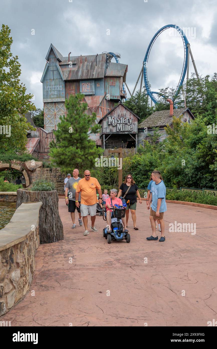 Family of park guests walking past the Mystery Mine roller coaster ride at the Dollywood ...