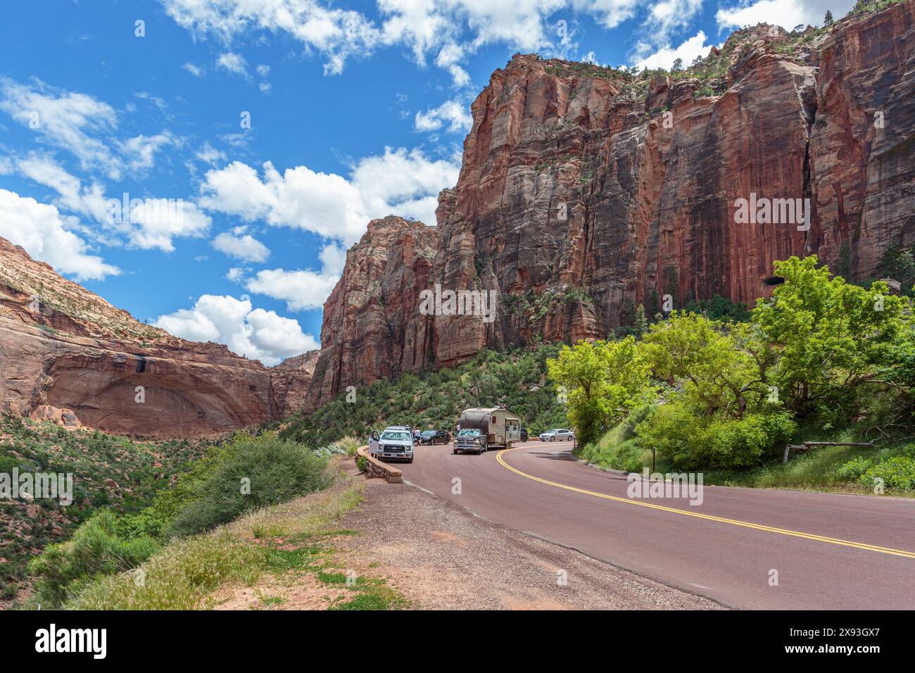 Recreational vehicle passes tourists at an overlook next to a blind ...