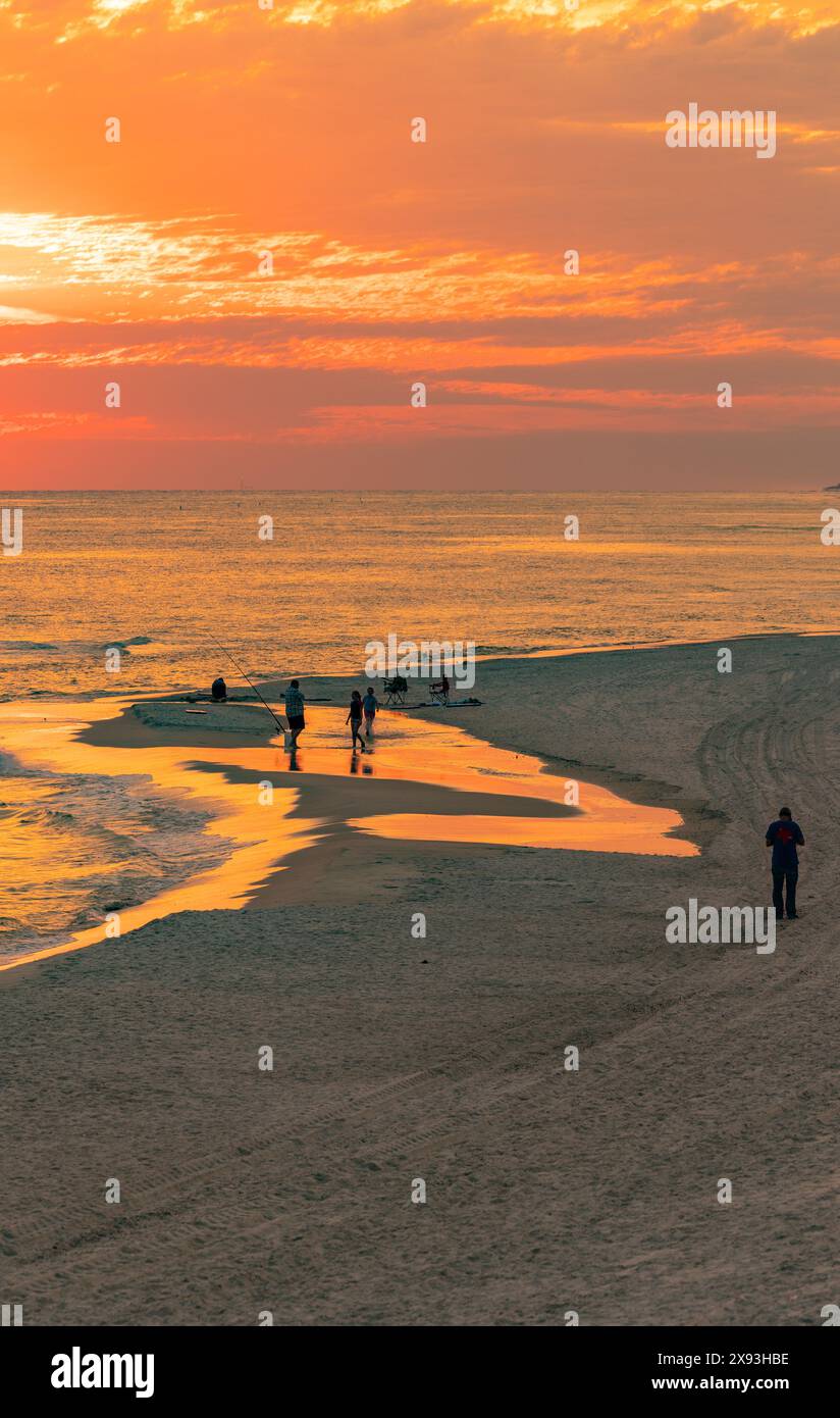 People playing and fishing on the beach at sunset on the Gulf of Mexico ...
