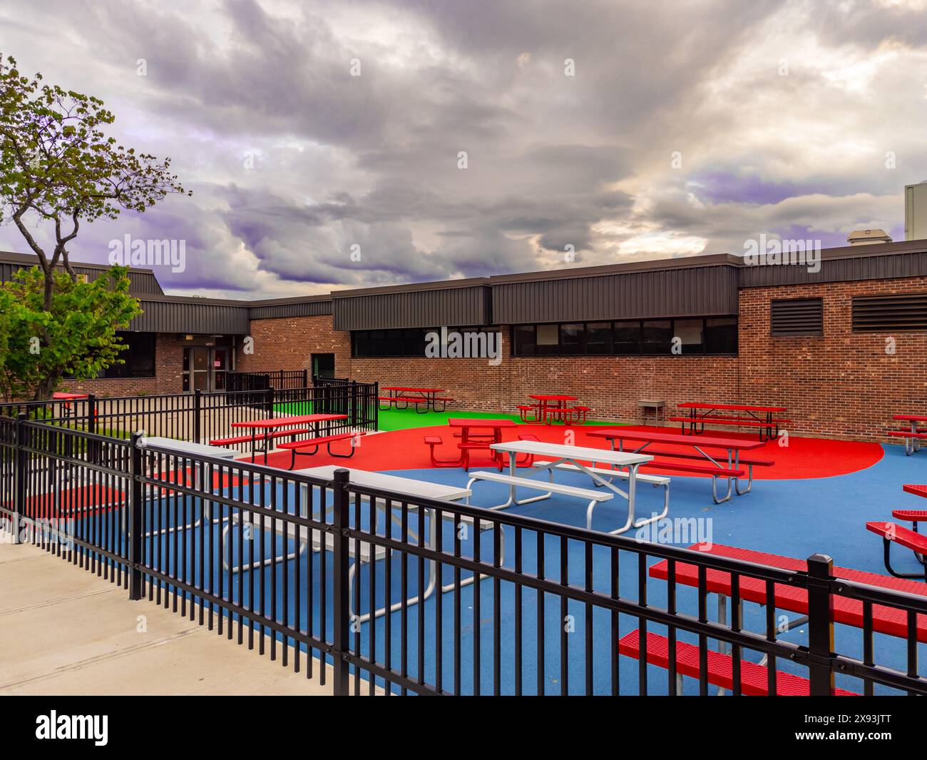 Red vinyl coated picnic table on a multi color playground surface Stock ...